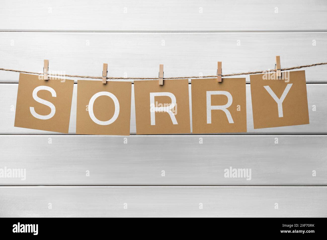 Word Sorry made of paper notes with letters hanging on rope against ...