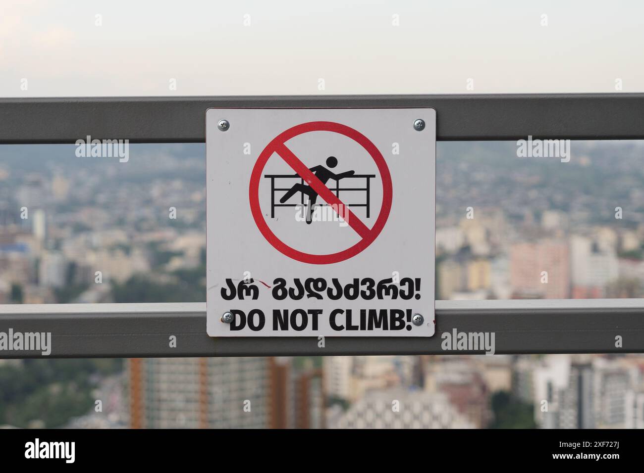 A red warning sign on a rooftop saying DO NOT CLIMB in English and ...