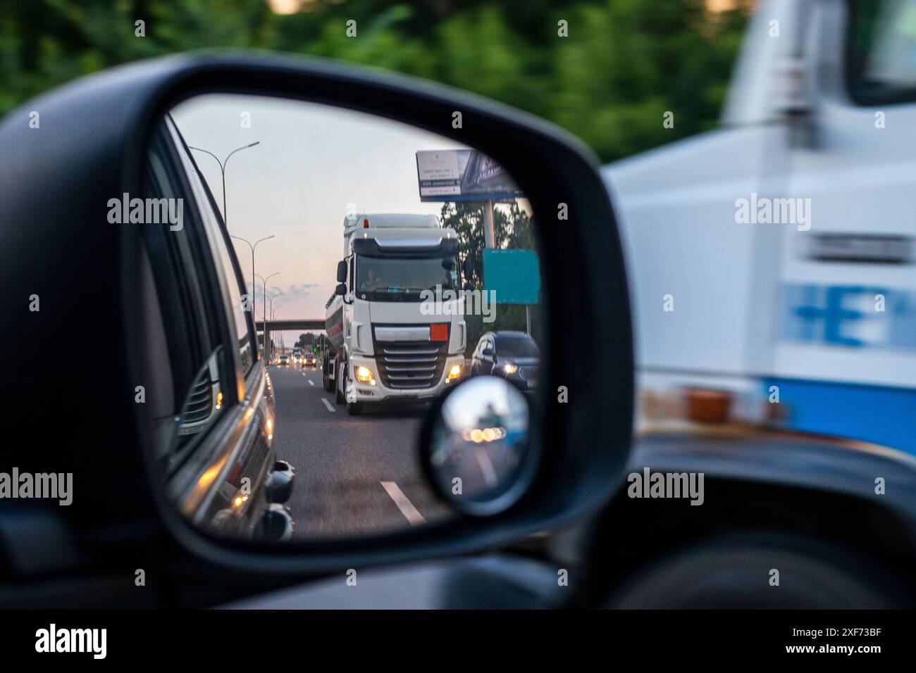 truck in the car's right side mirror while the car is driving in the ...