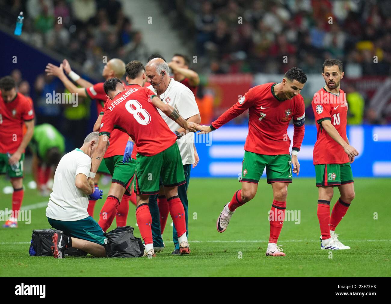 Portugal's Cristiano Ronaldo helps Bruno Fernandes tp his feet during ...