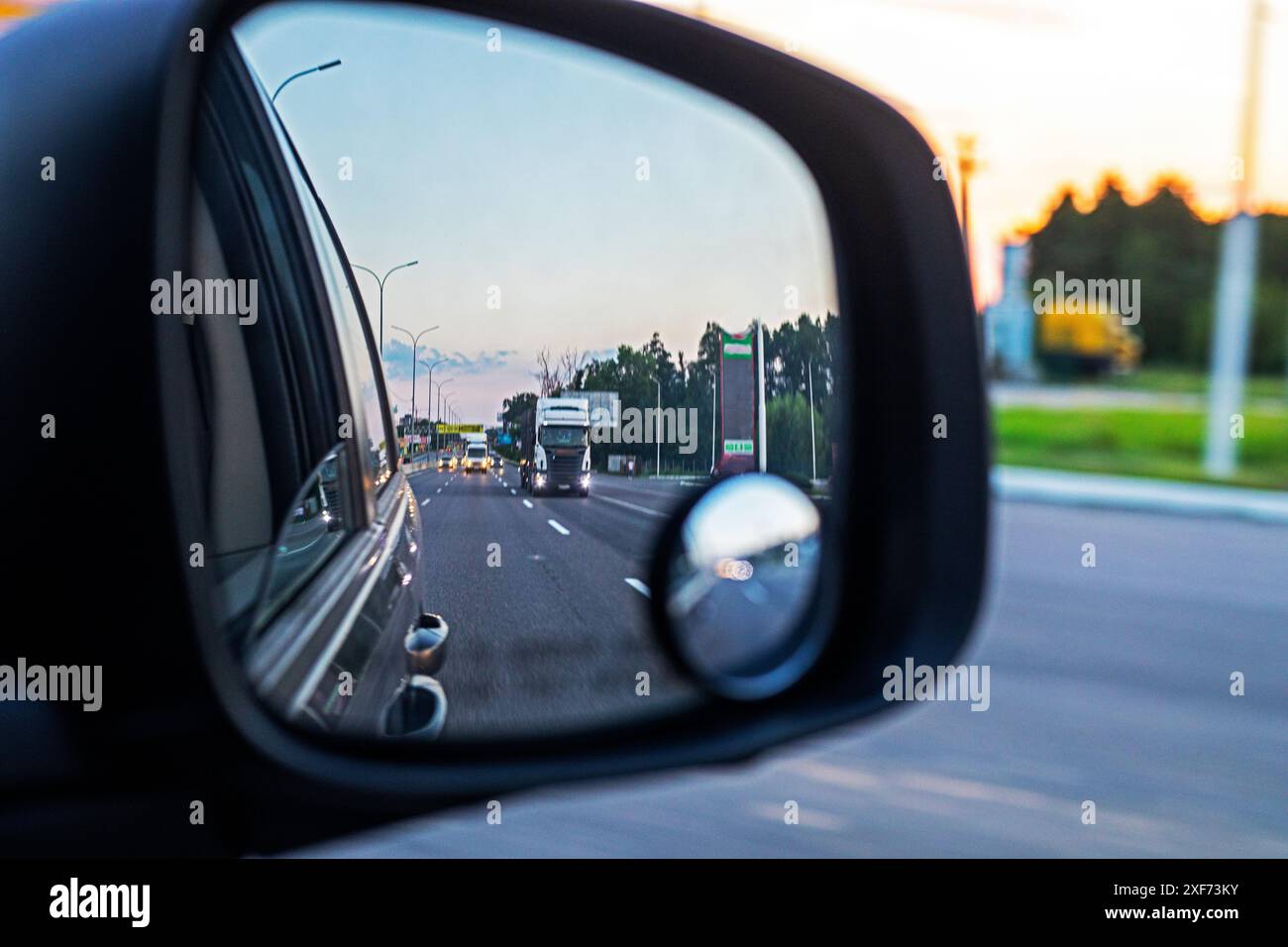 truck in the car's right side mirror while the car is driving in the ...