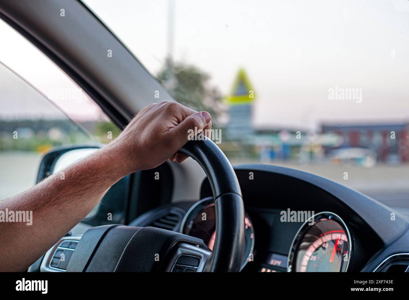 male driver is driving a car during a traffic jam in the capital ...