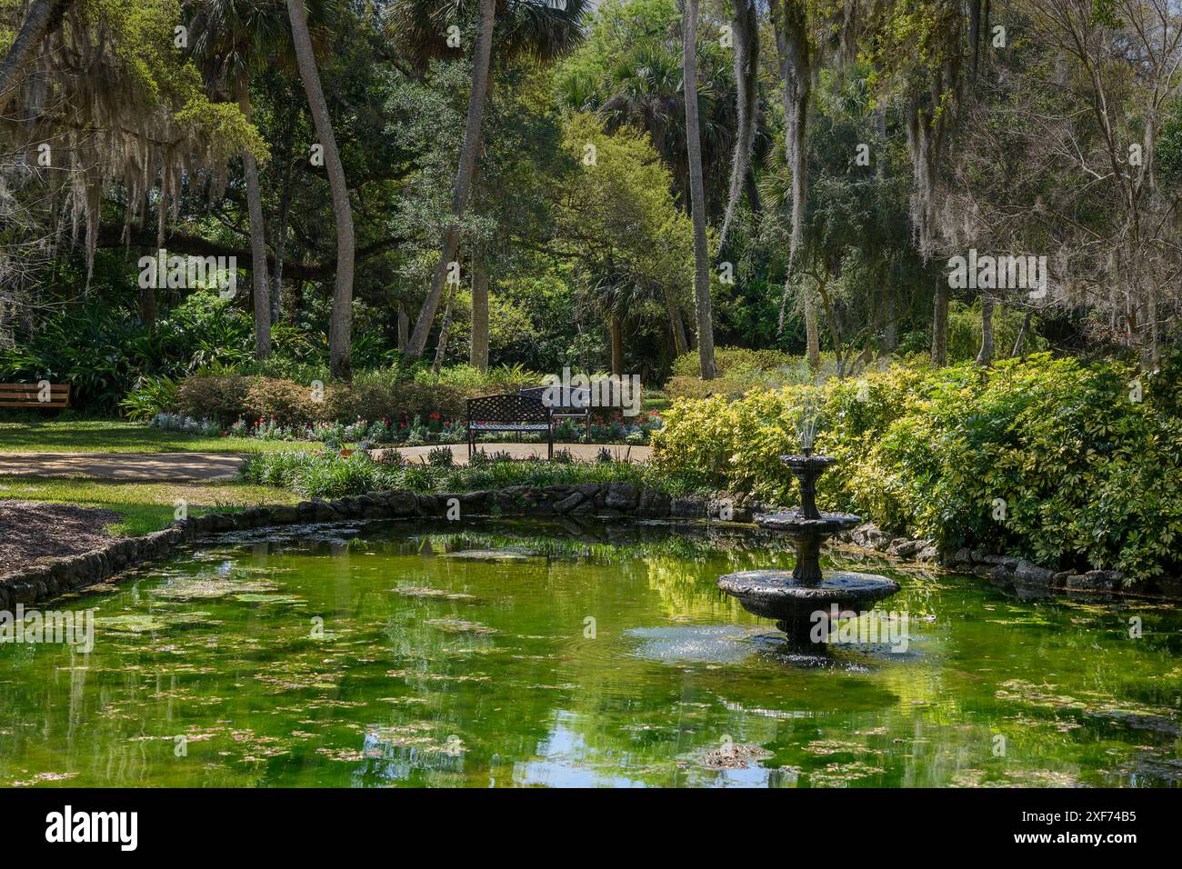 Fountain in pond with seating area Stock Photo - Alamy