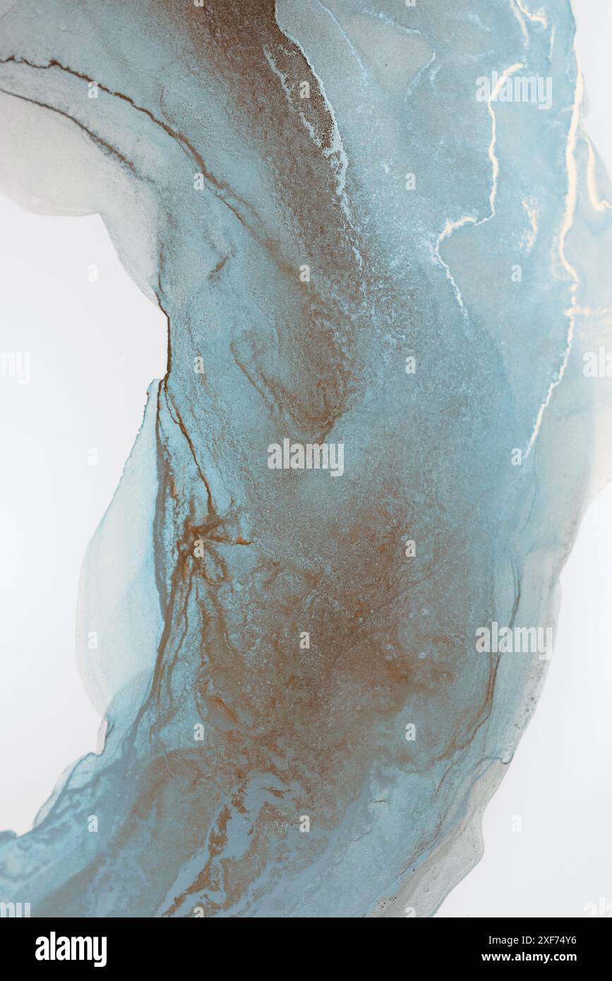 A close-up of a blue and brown ink swirl on a white background ...