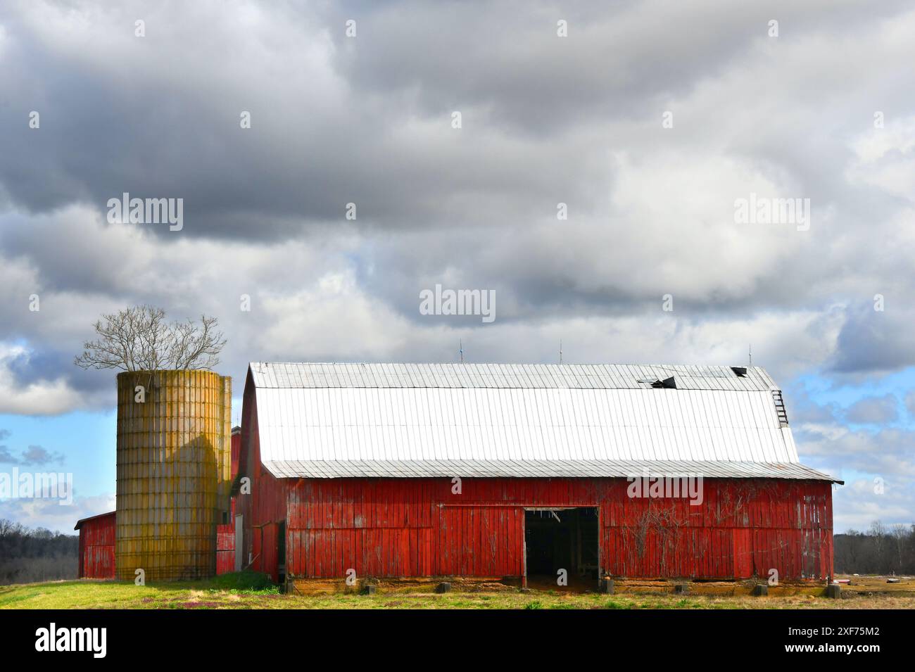 Two barns stand together. Both are wooden and painted red. Front barn ...