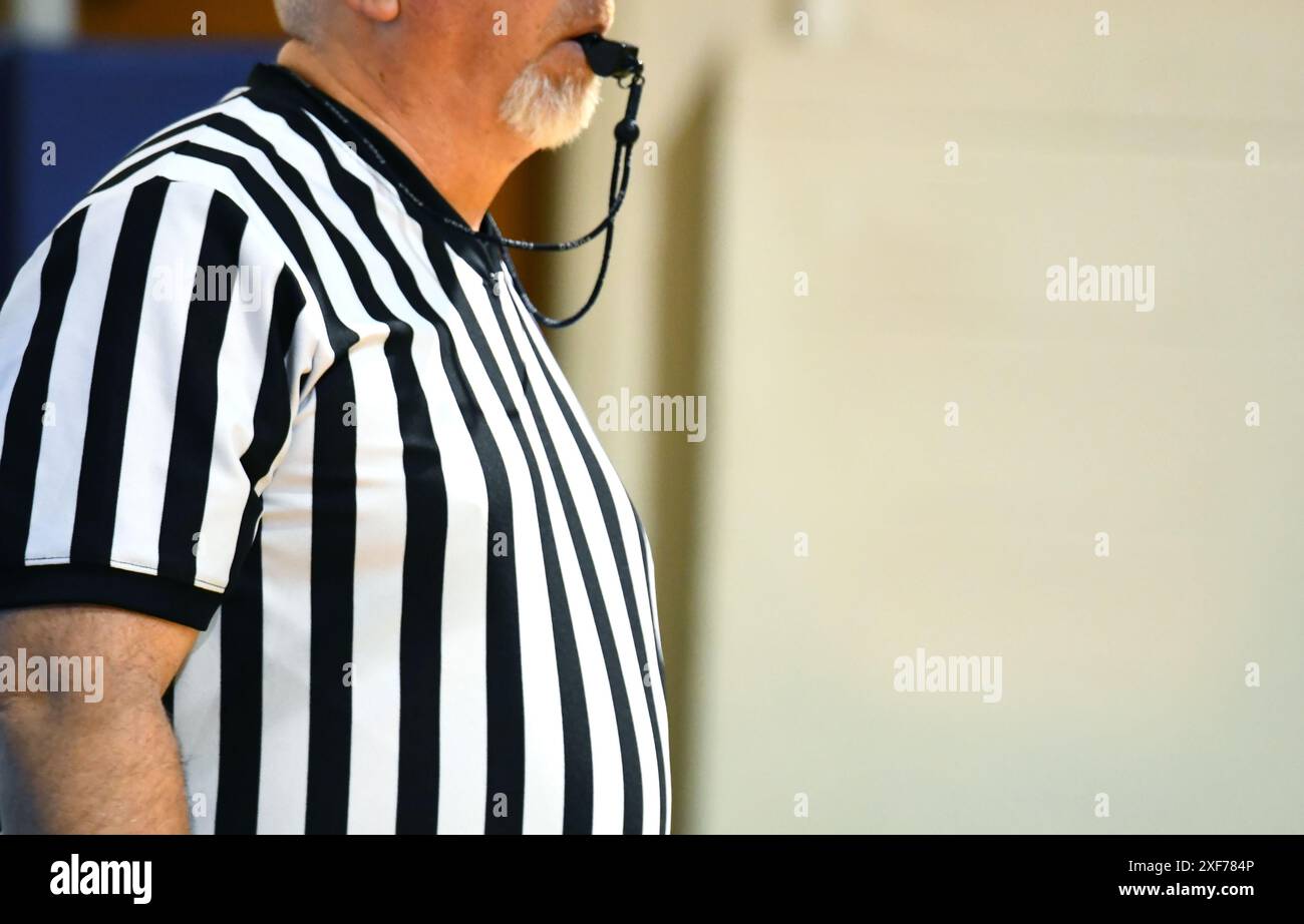 Referee blows whistle after a foul, during a high school varsity ...
