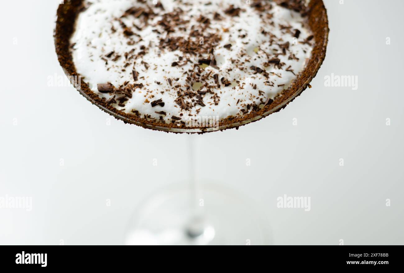 A chocolate martini is poured into a martini glass. The drink is topped ...
