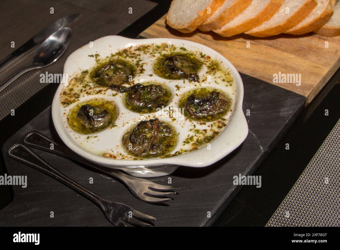 Oven baked escargot with french bread for dipping Stock Photo - Alamy