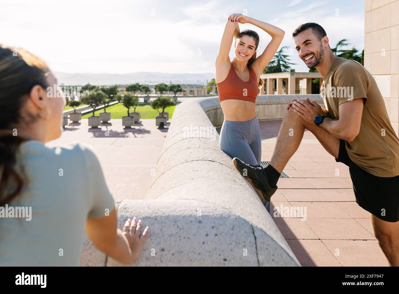 Three fitness friends doing stretching exercise after workout routine ...
