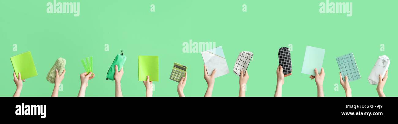 Many hands holding school supplies on green background Stock Photo - Alamy