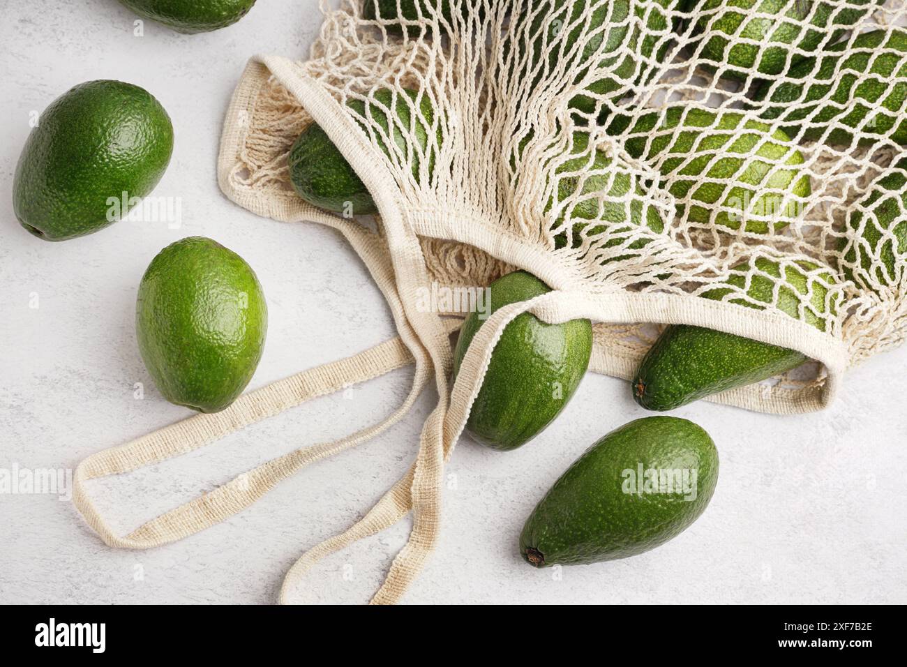 String bag with fresh ripe avocados on white background Stock Photo - Alamy