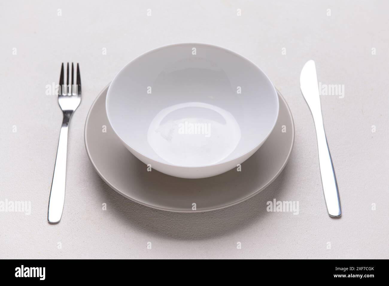 Table setting with clean plates and cutlery on white background Stock ...