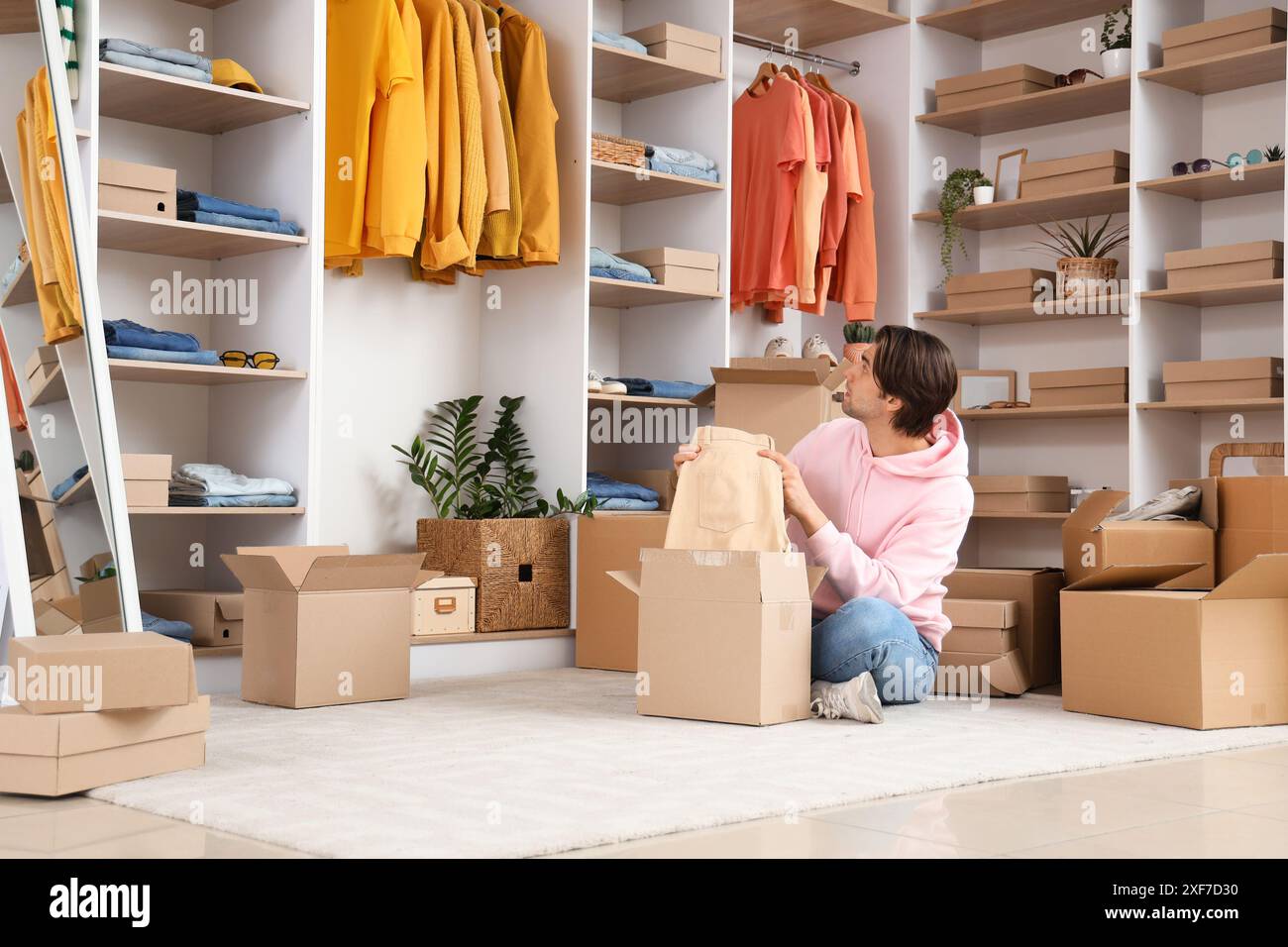 Handsome young man with wardrobe boxes sitting in dressing room Stock ...