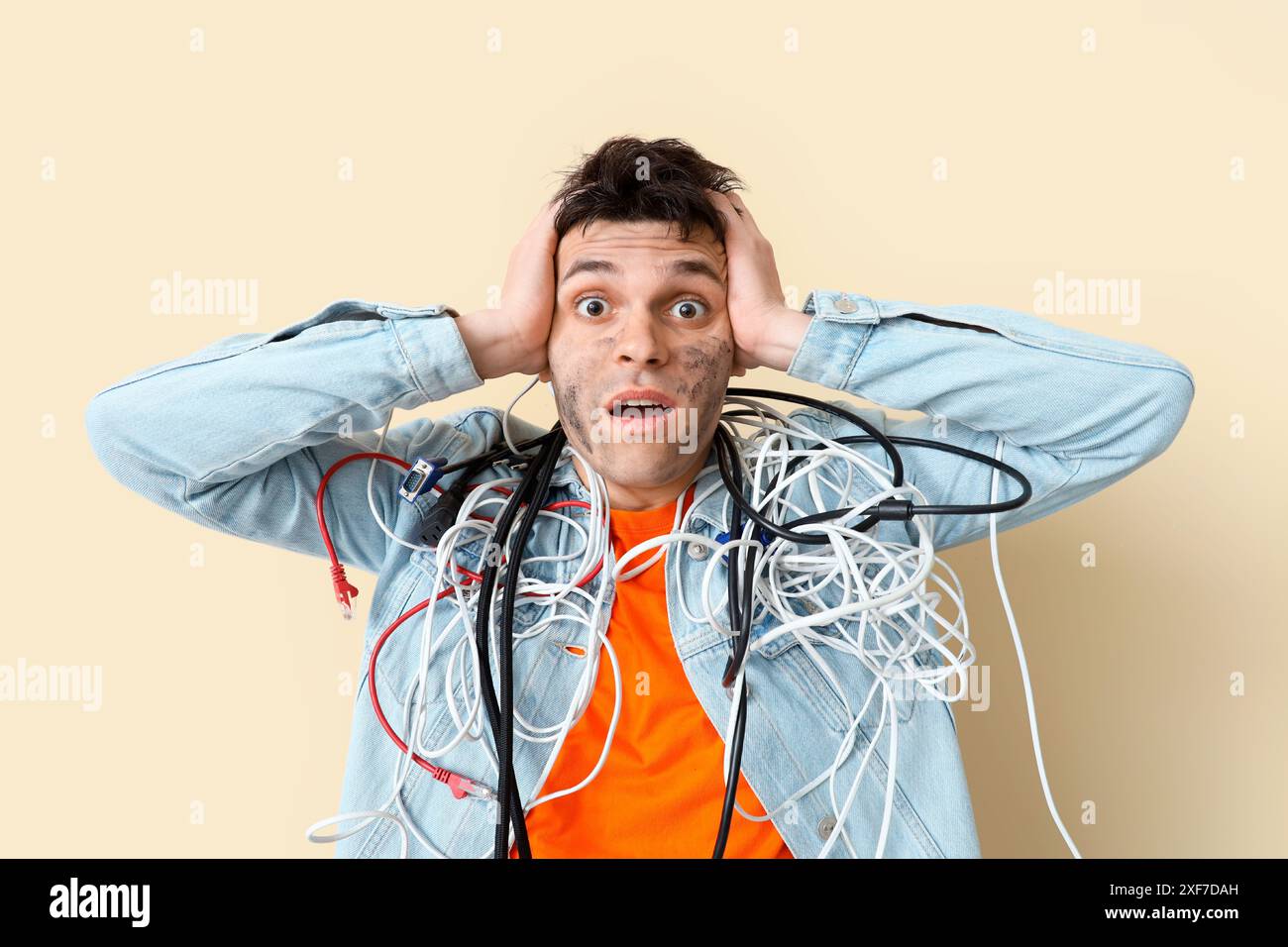 Electrocuted young man with burnt face and wires on beige background ...