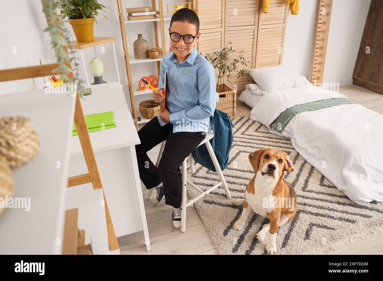 Little African-American boy studying with cute beagle dog at home Stock ...