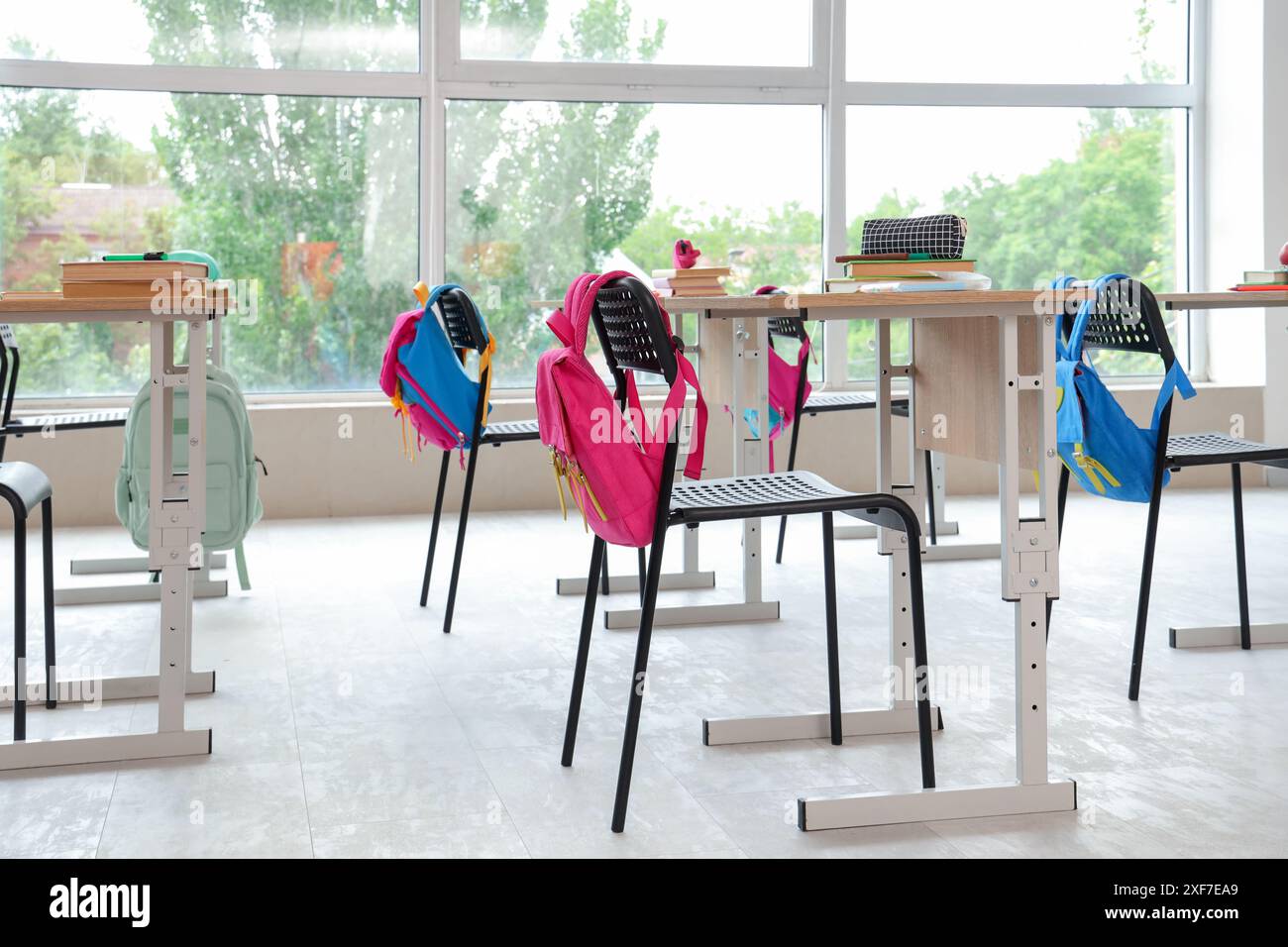 Chairs with backpacks and desks in classroom Stock Photo - Alamy