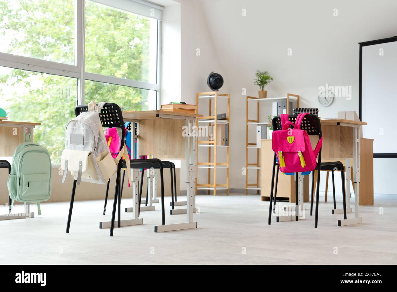 Interior of light classroom with desks and backpacks Stock Photo - Alamy