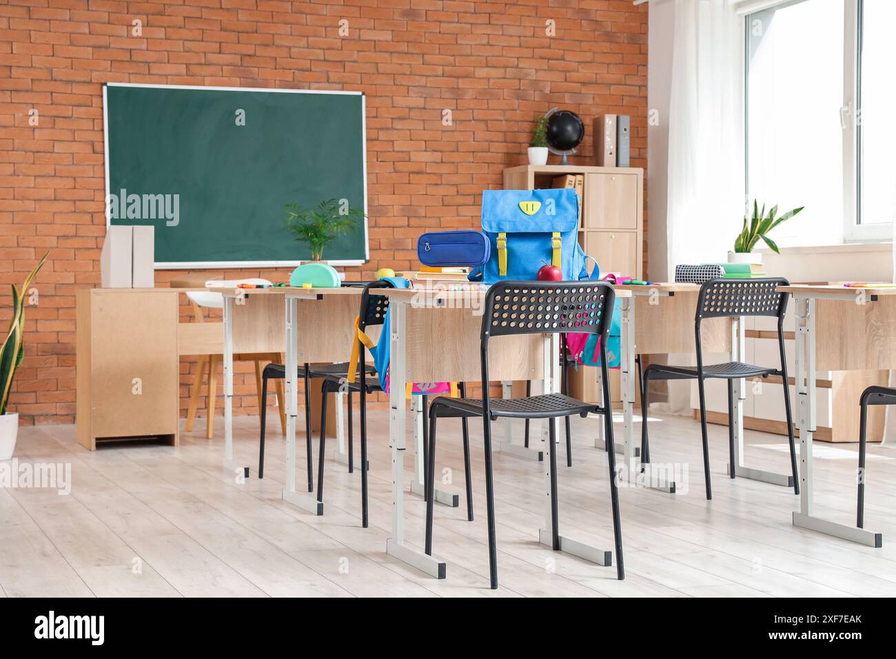 Interior of classroom with chalkboard, desks and backpacks Stock Photo ...