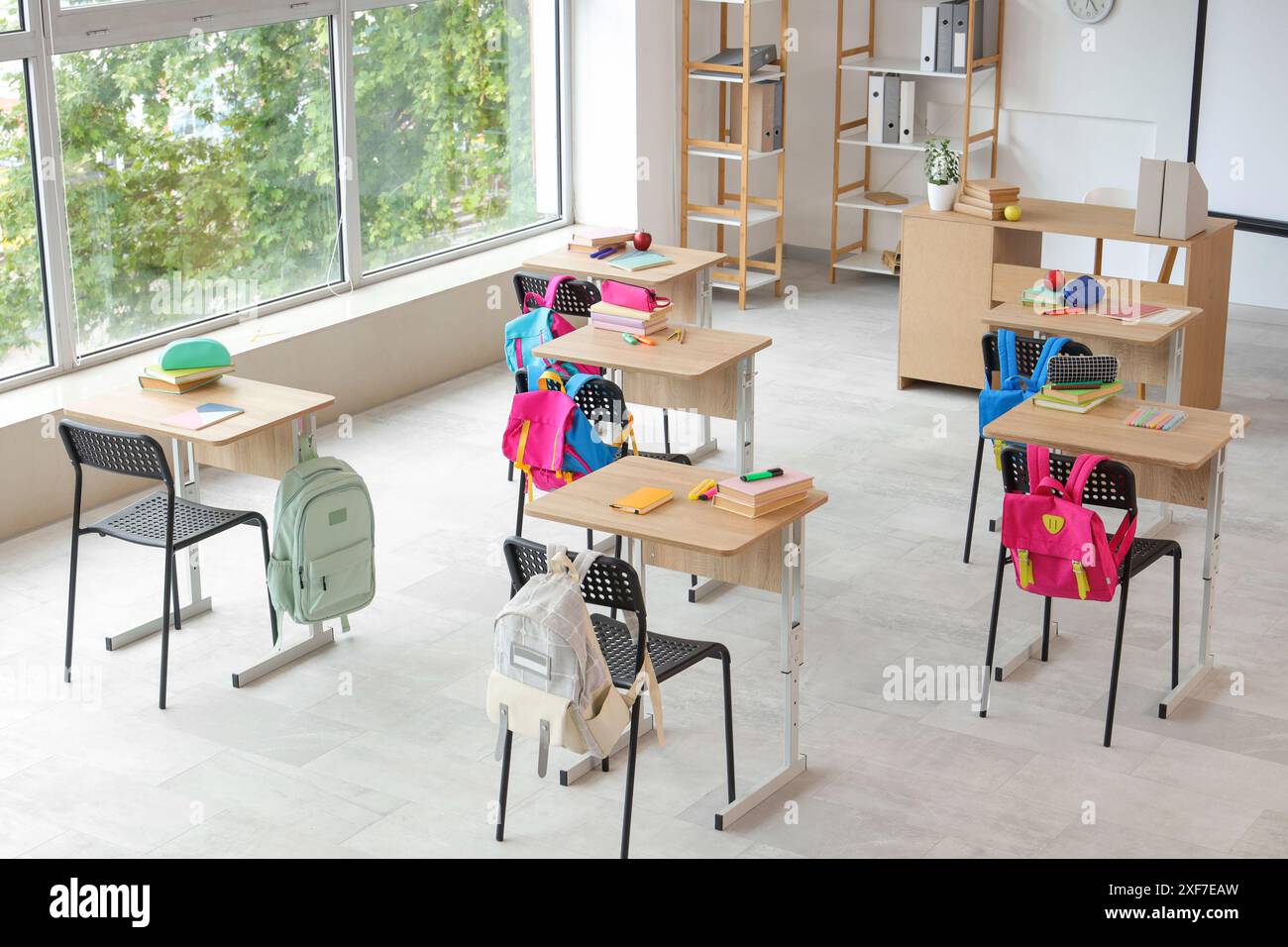 Interior of light classroom with desks and backpacks Stock Photo - Alamy
