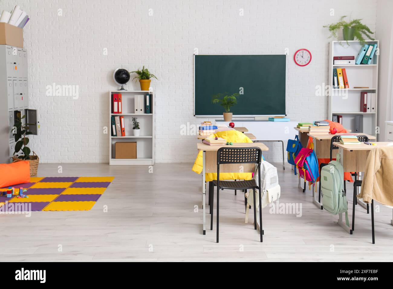 Interior of classroom with chalkboard, desks and shelf units Stock ...