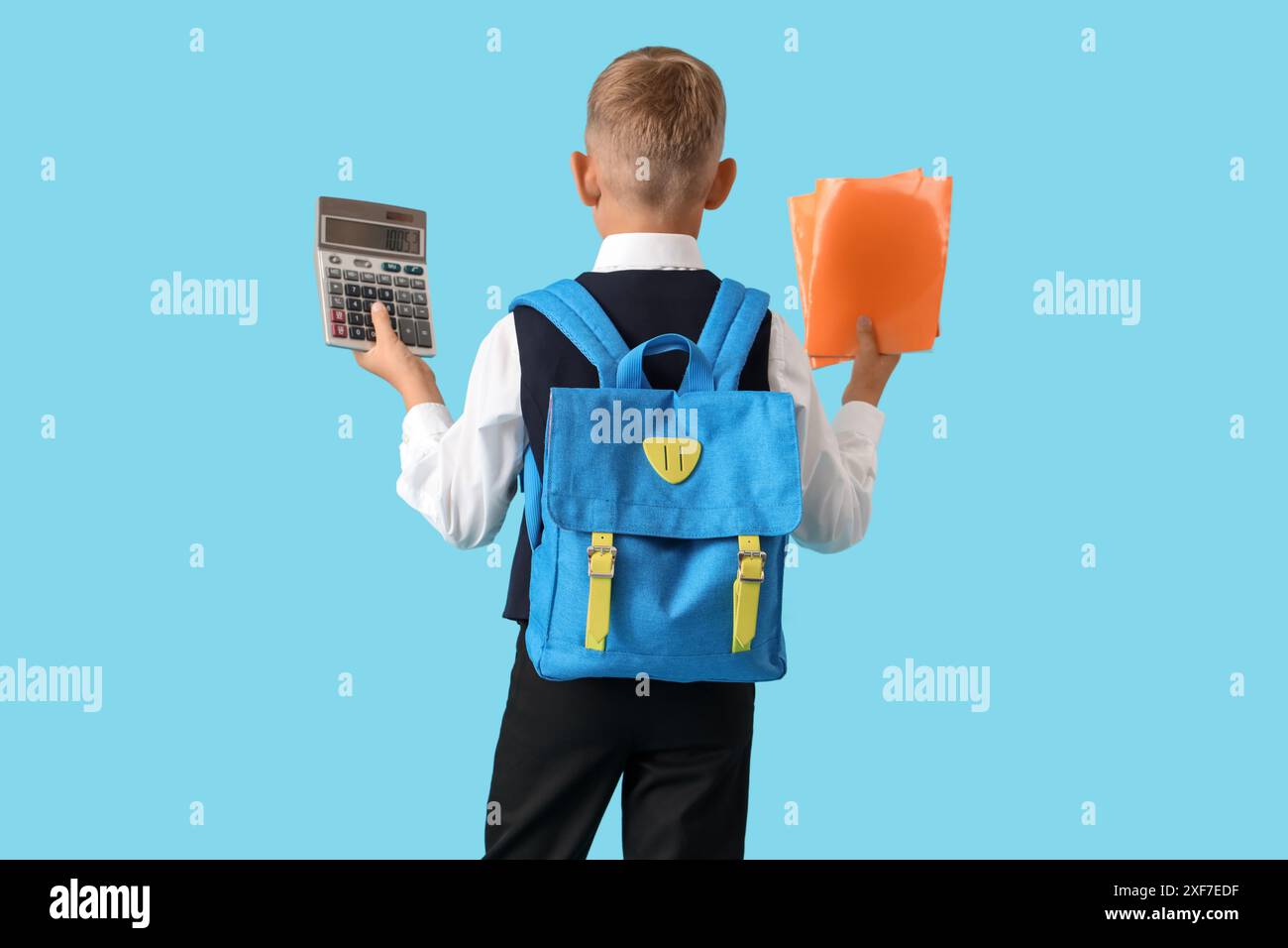Little boy with backpack, calculator and notebooks on blue background ...