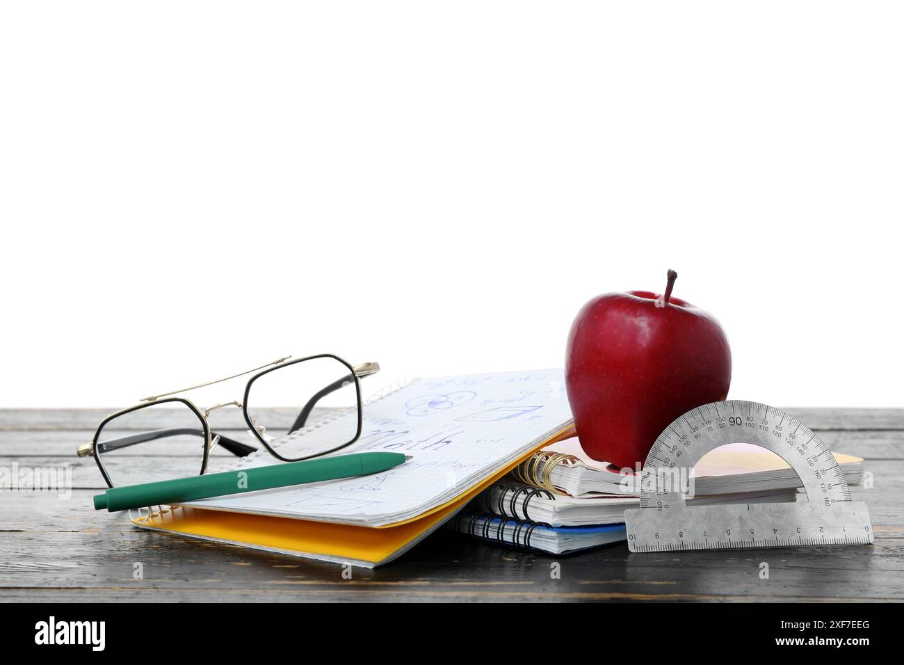 Red apple and school supplies with eyeglasses and protractor on table ...