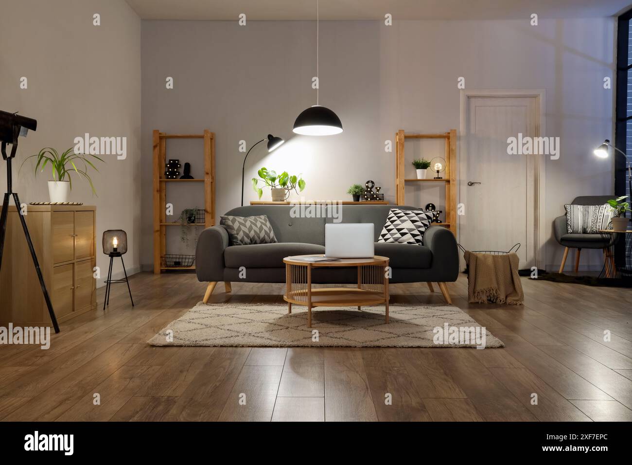 Interior of living room with comfortable sofa, table, racks and glowing ...