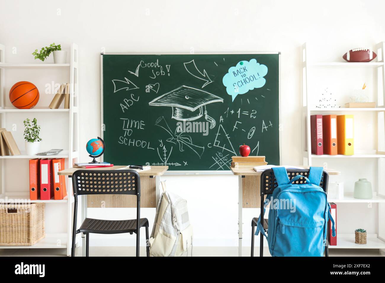 Interior of empty classroom with blackboard, shelf units and desks ...