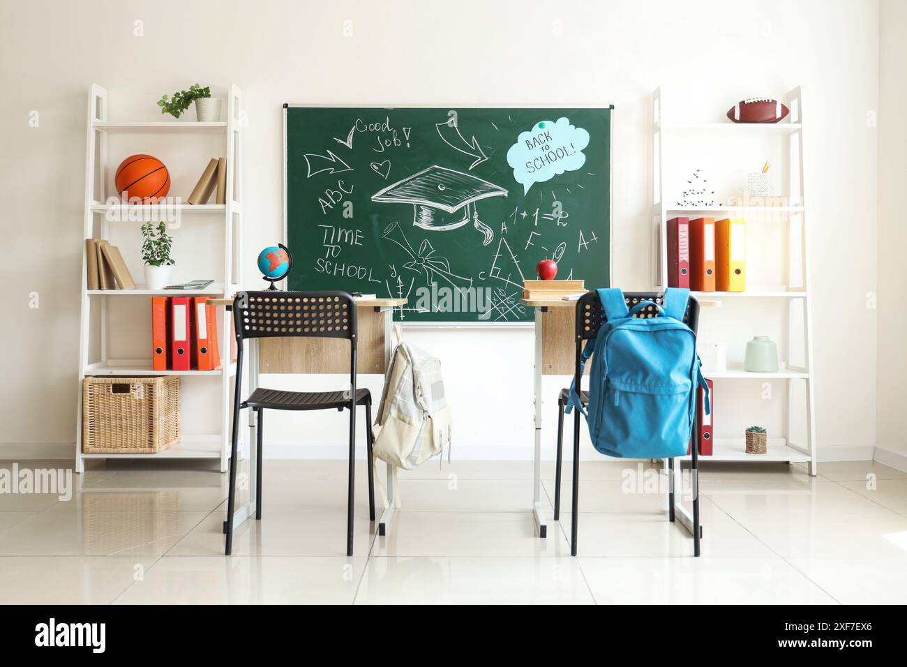 Interior of empty classroom with blackboard, shelf units and desks ...