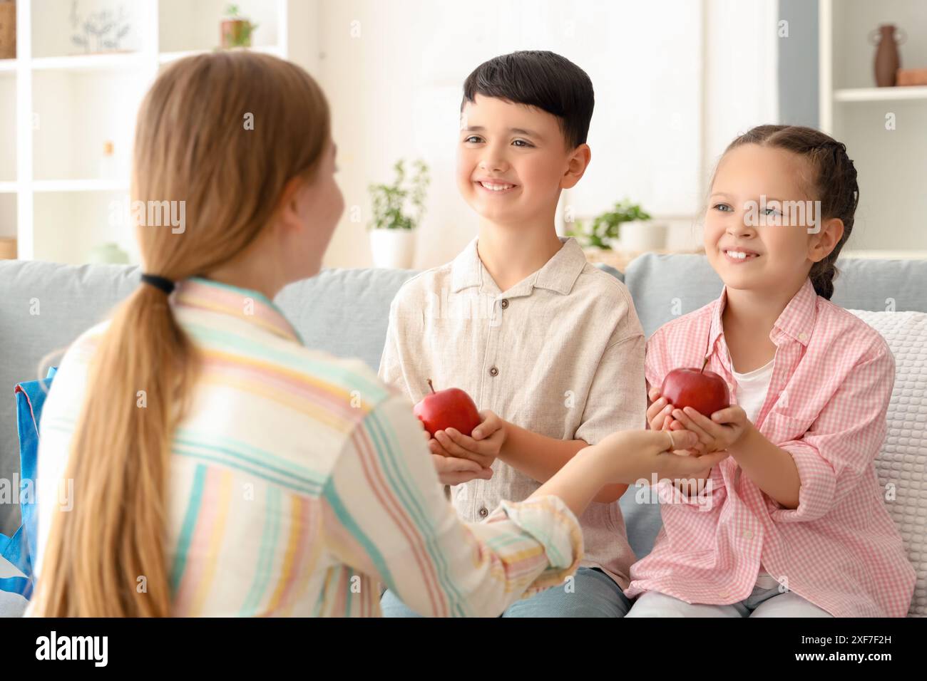 Little children taking apples from their mother at home Stock Photo - Alamy