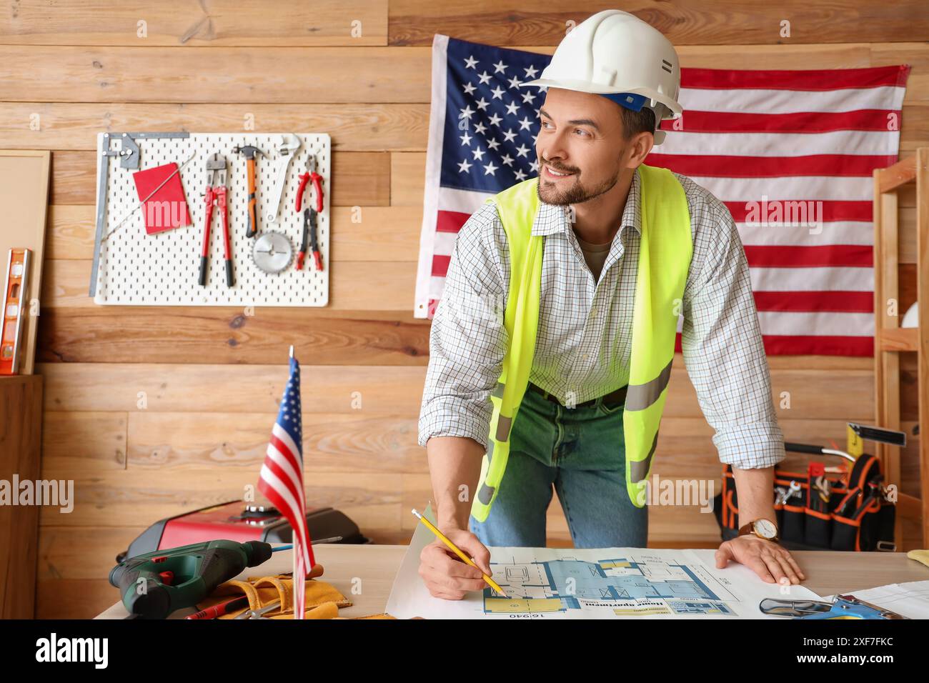 Male architect working with house plan in workshop. Labour Day ...