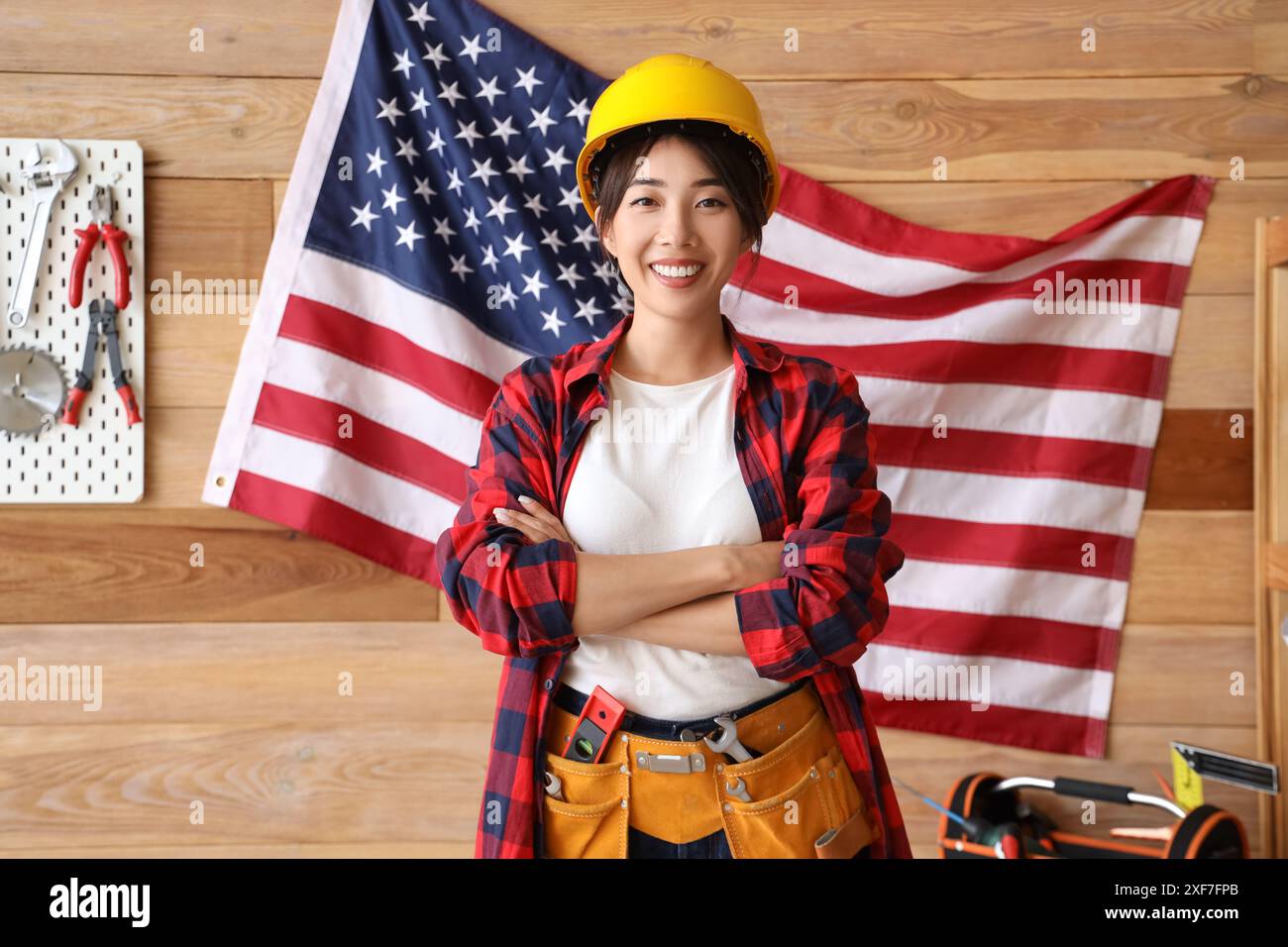 Female Asian worker against USA flag in workshop. Labour Day ...