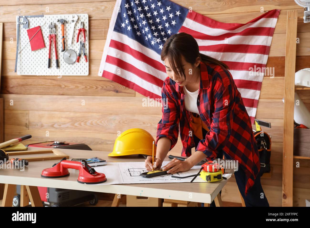 Female Asian worker with house plan in workshop. Labour Day celebration ...