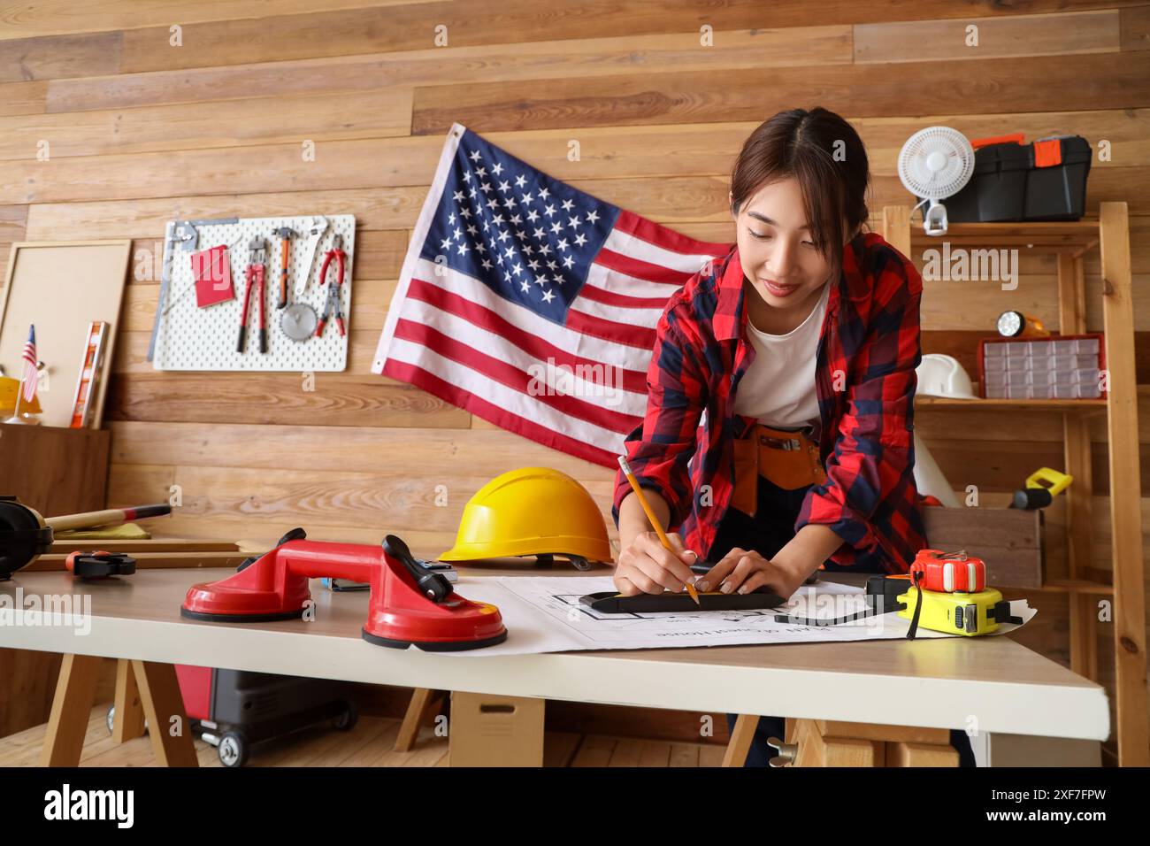 Female Asian worker with house plan in workshop. Labour Day celebration ...