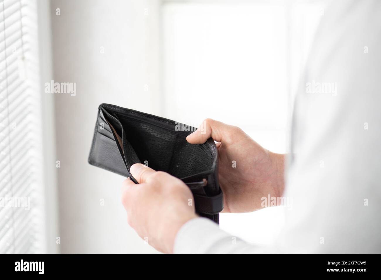A man holding an empty wallet close up, hands of poor man open empty ...