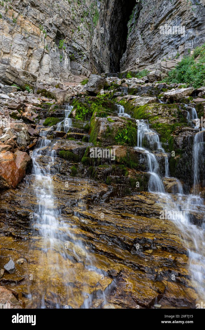 USA, Wyoming. Waterfall coming out of Wind Cave, Teton Mountains Stock Photo - Alamy