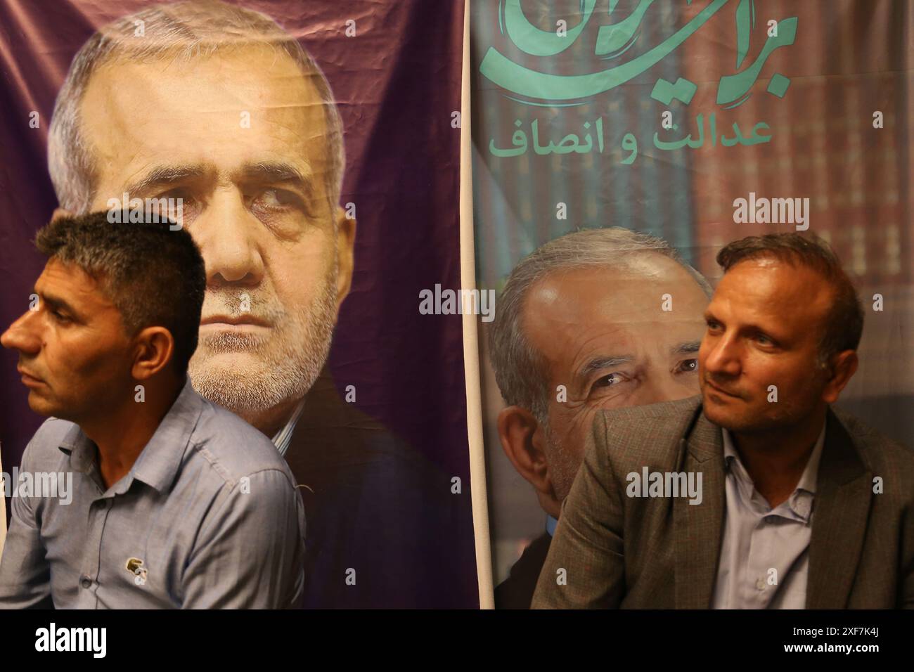 July 1, 2024, Tehran, Iran: Two Iranian men sit next to posters ...