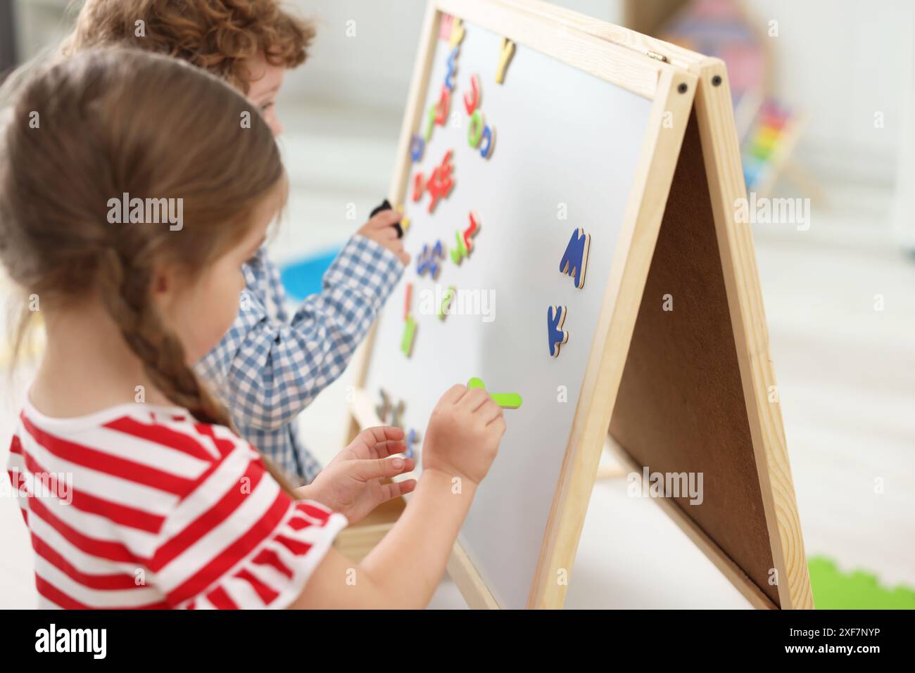 Little children learning alphabet with magnetic letters on board in ...