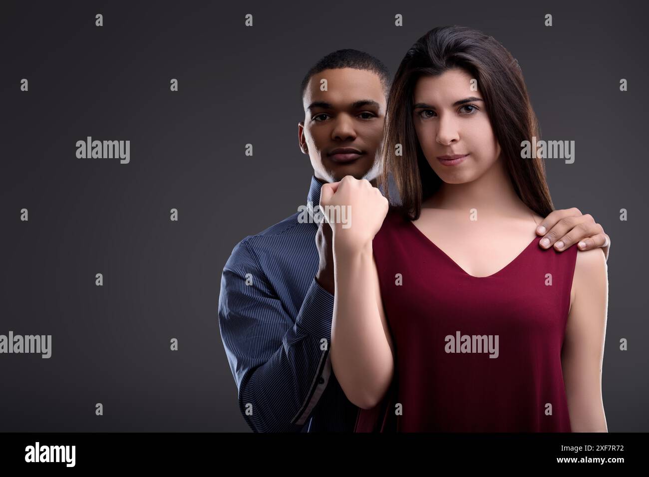 Stylish, multiethnic couple poses confidently in a studio, showing love ...