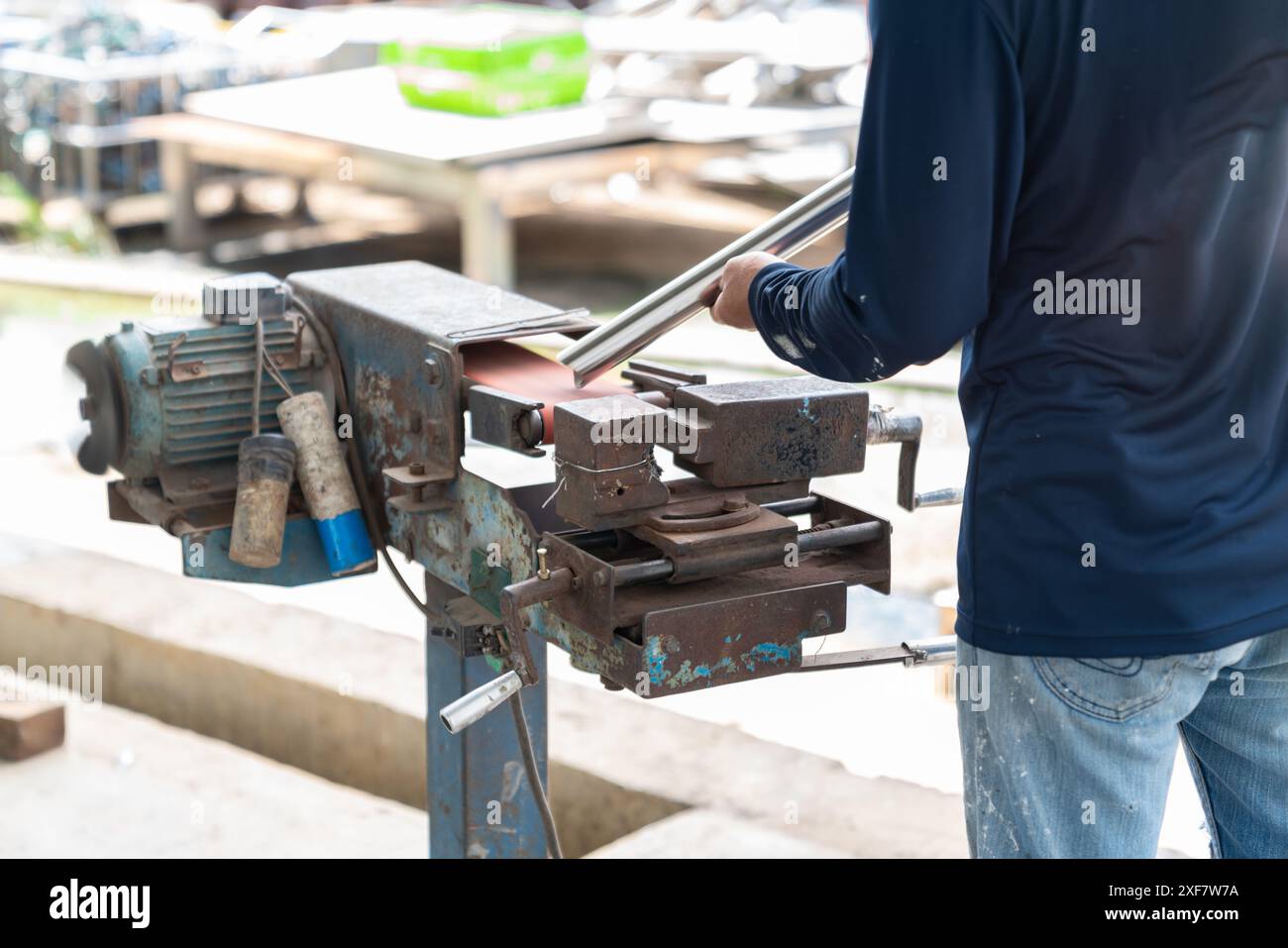 Industrial tool worker grinds a edge curve steel pipe on a rotating ...