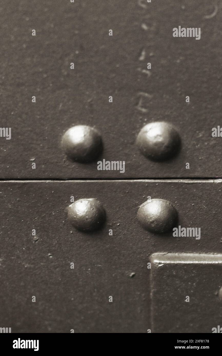 Close-up vertical photo of a fragment of armor with rivets of a ...
