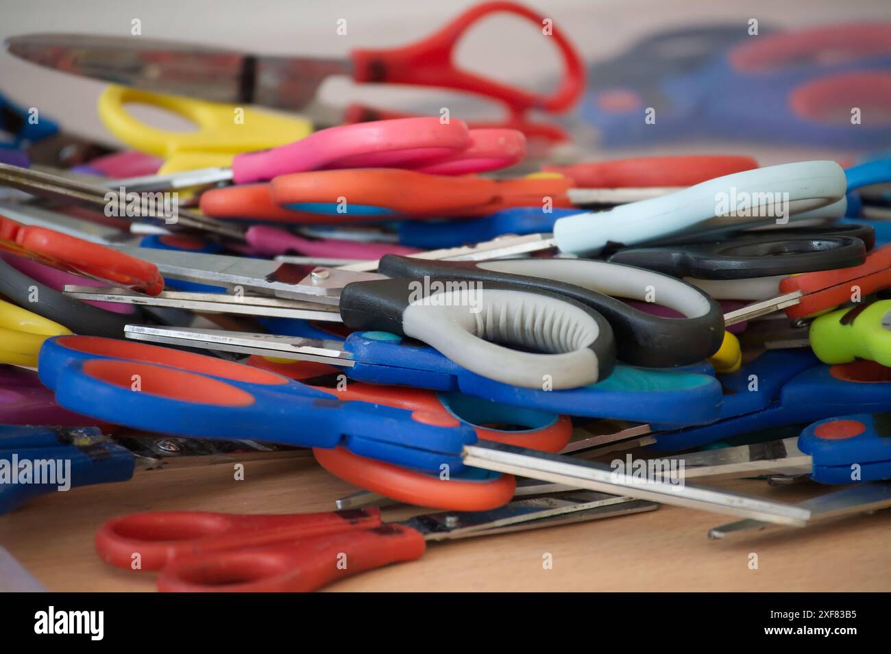 A diverse collection of colorful scissors stacked together, commonly ...