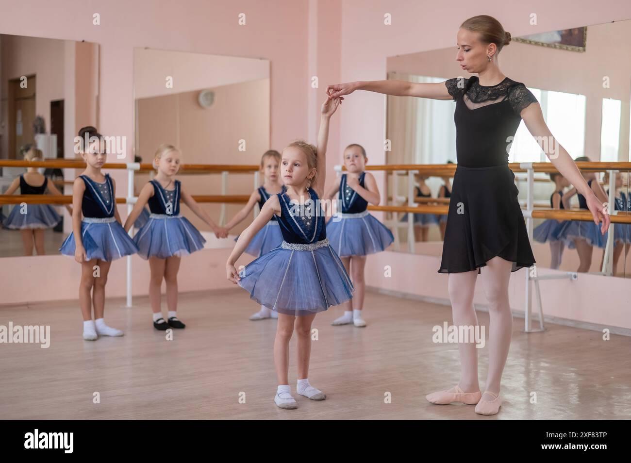 Children's ballet school. Caucasian woman teaching ballet to little ...