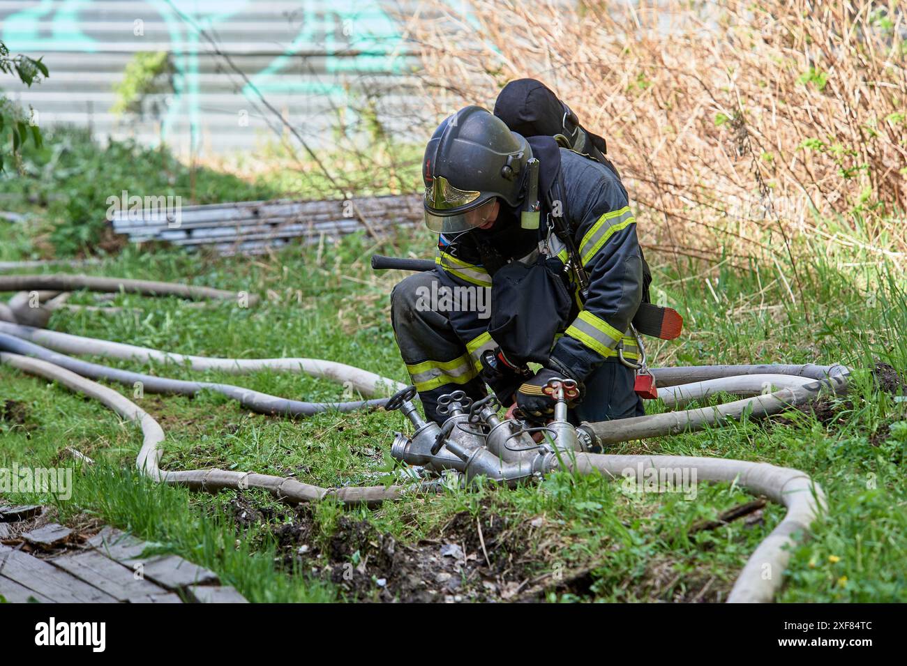 The firefighter connects the hoses to the water pump system splitter ...