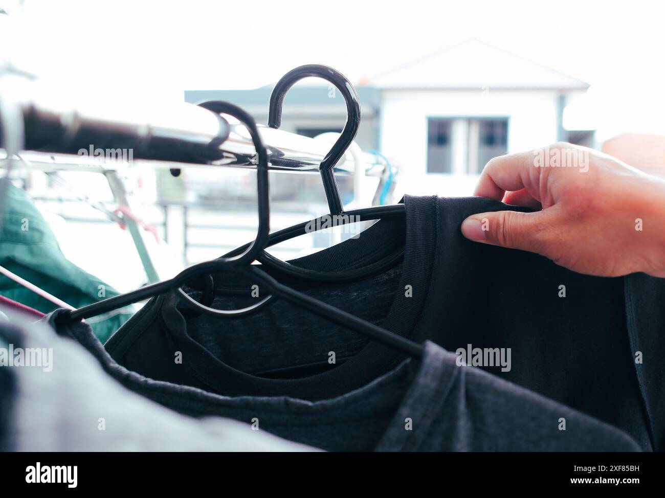 Human hands hanging washed clothes on a clothesline in the house ...