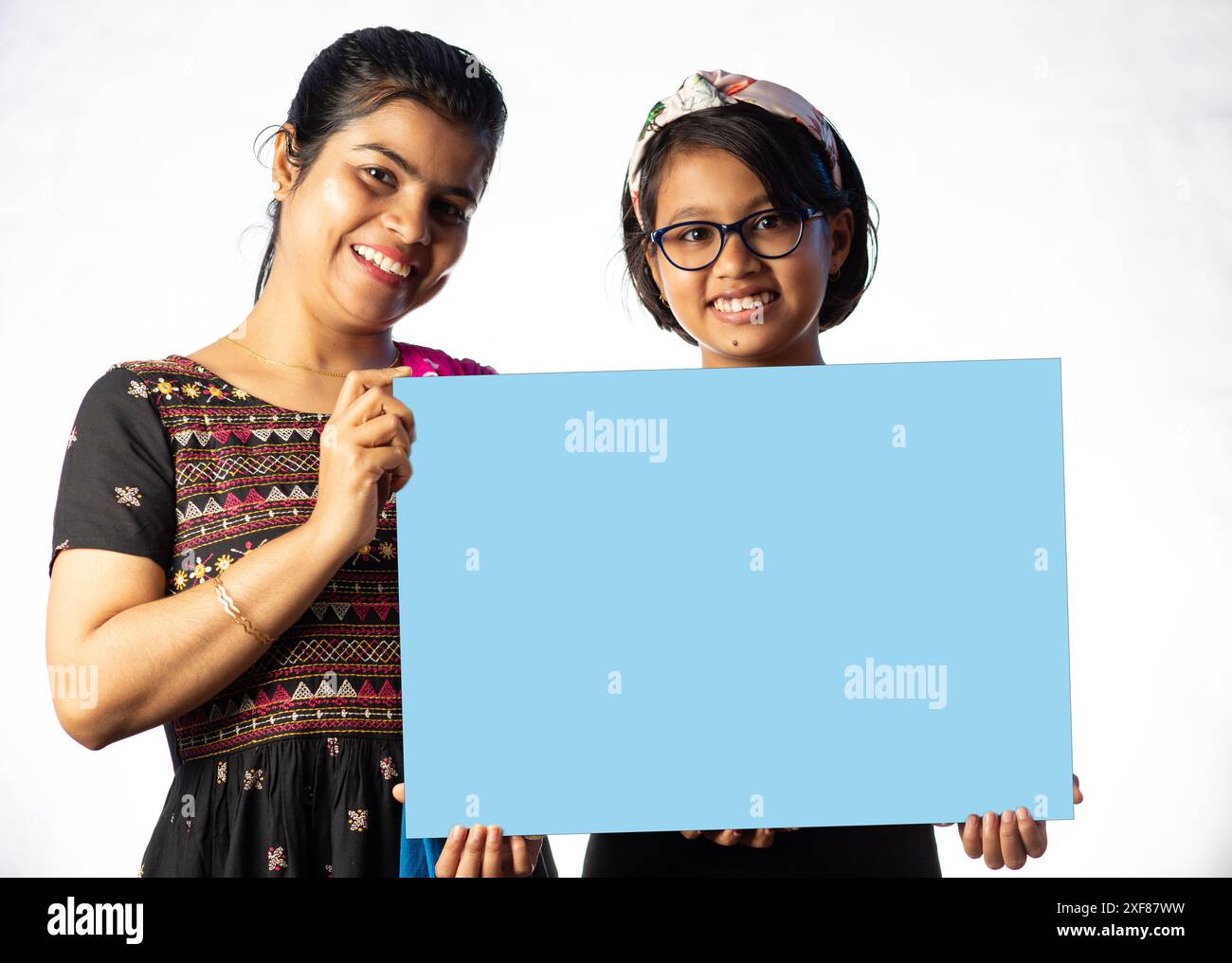 An Indian pretty girl child smiling and showing cyan color blank ...