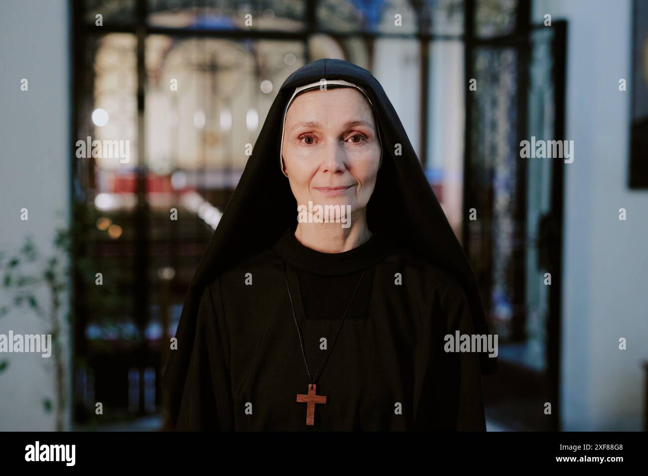Medium closeup portrait of mature Caucasian Catholic nun standing ...