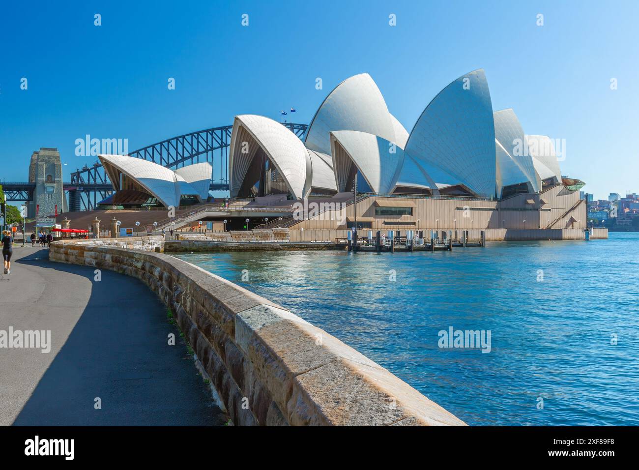 Sydney Opera House and Sydney Harbour Bridge in Sydney, Australia, seen from the seawall of the ...