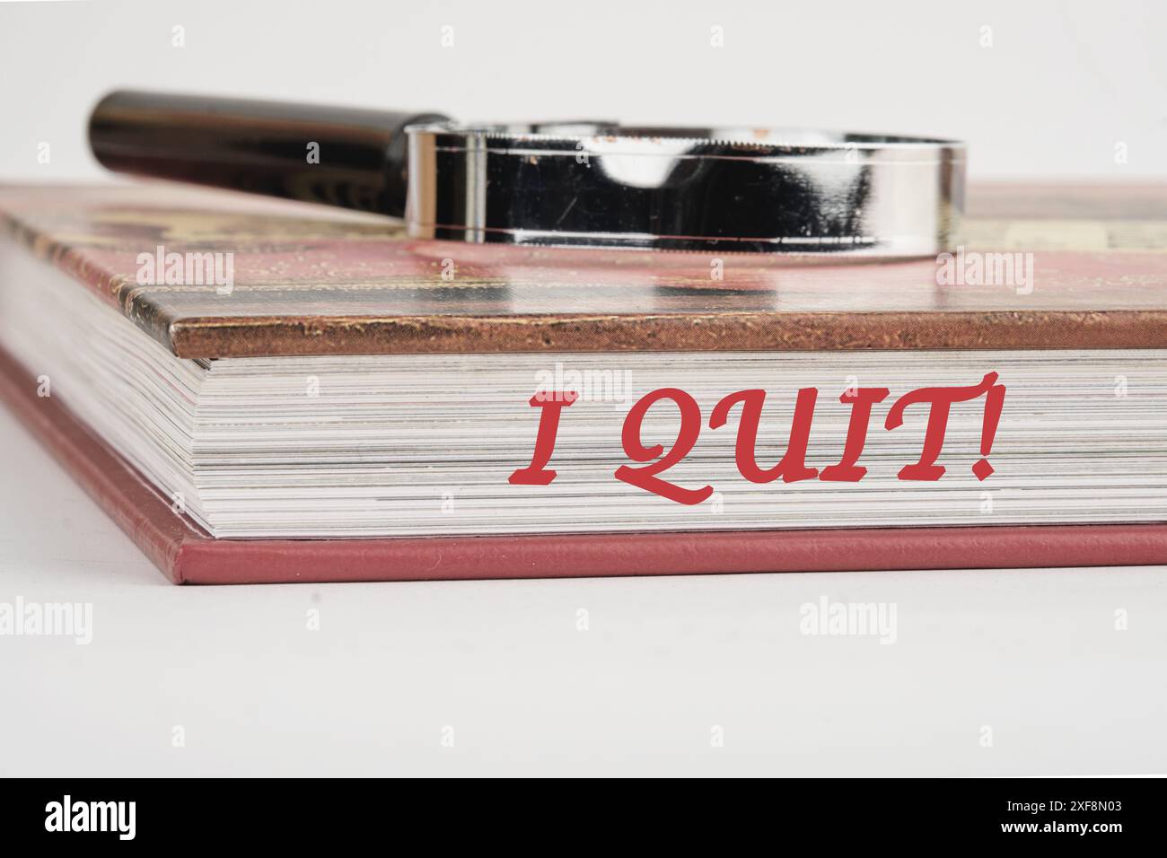I Quit word on the end of the book with a magnifying glass on top on a ...