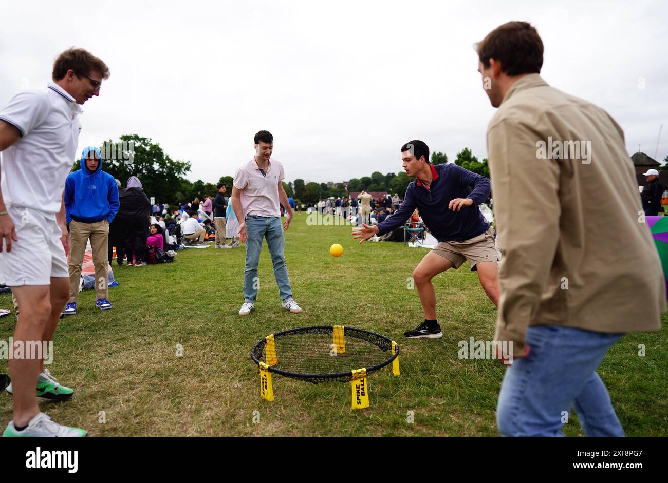Spectators in the queue play a game of spike ball on day two of the ...
